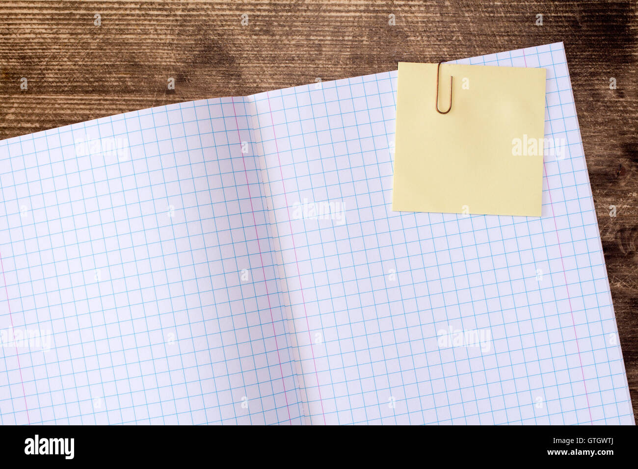 Squared exercise book with blank yellow sticky note Stock Photo - Alamy