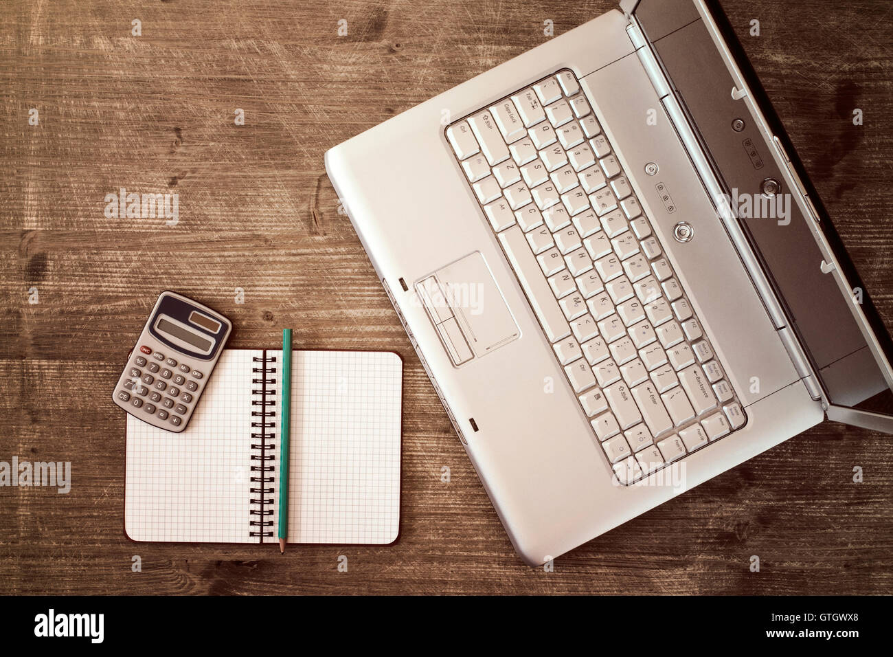 Top view working desk with laptop computer, calculator and spiral ...
