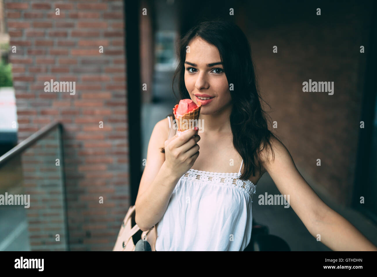 Beautiful woman eating ice cream outdoors Stock Photo - Alamy