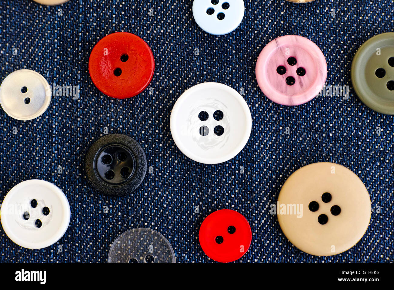 Some sewing buttons scattered on denim background Stock Photo - Alamy