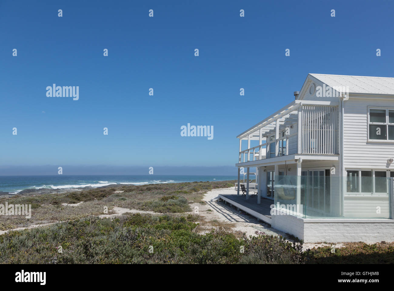 White beach house with ocean view under sunny blue sky Stock Photo - Alamy