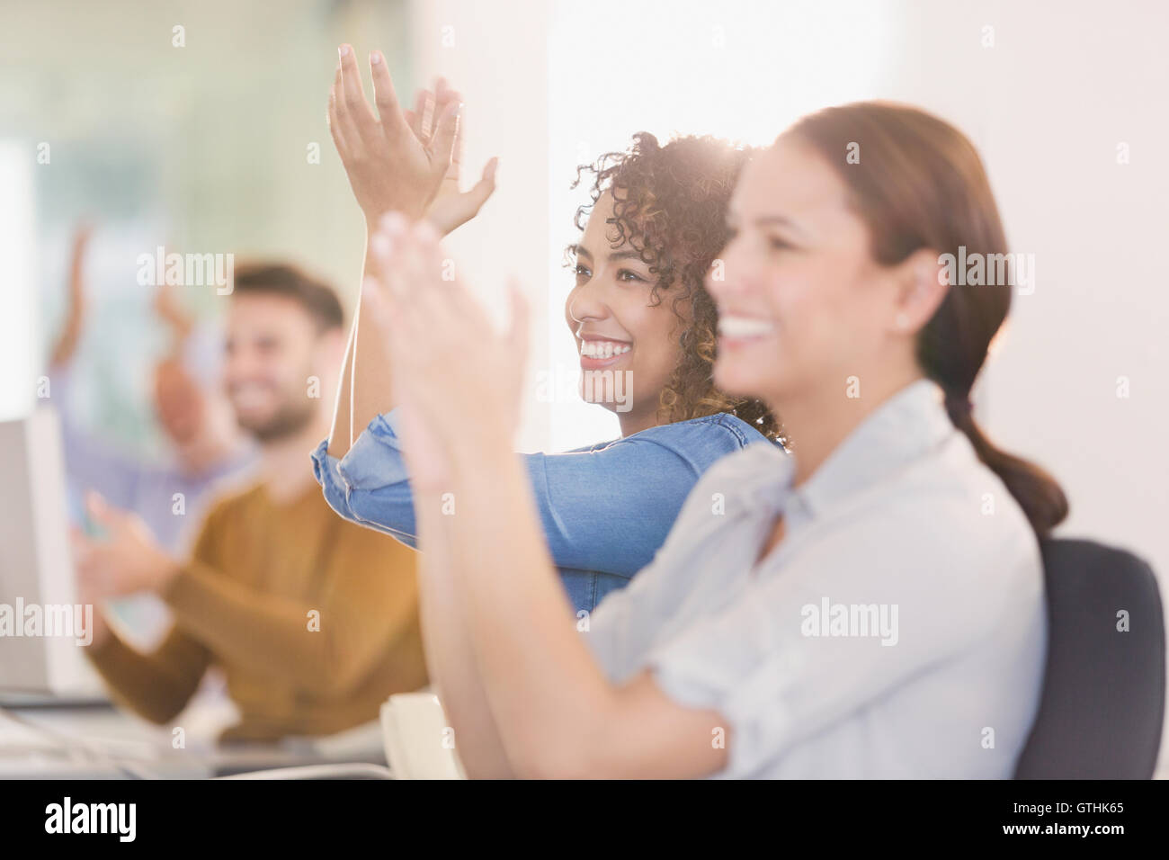 Businesswomen smiling and clapping in meeting Stock Photo - Alamy