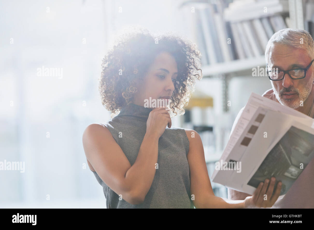 Designers discussing paperwork in meeting Stock Photo - Alamy