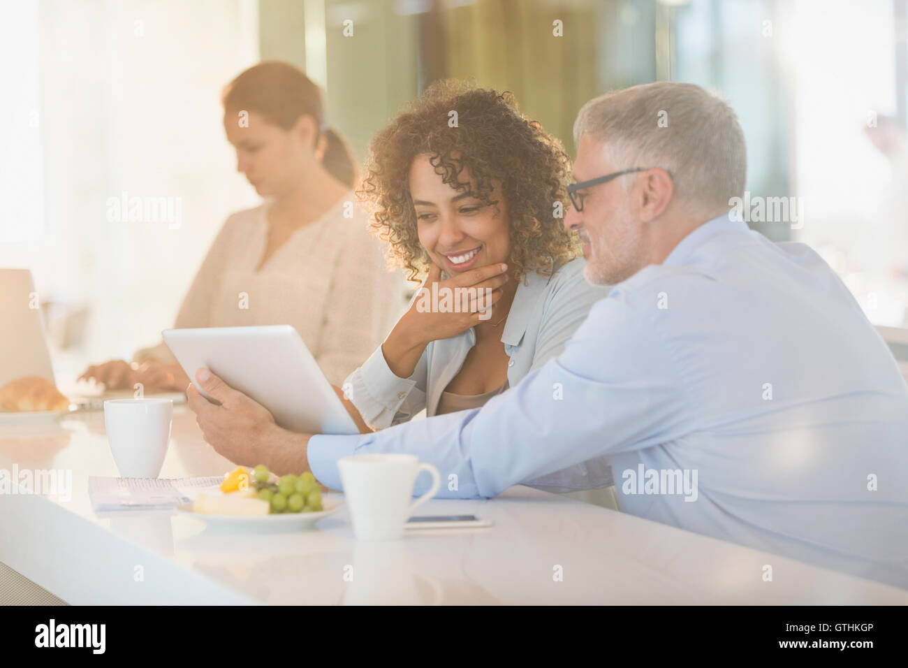 Business people with digital tablet meeting in office Stock Photo - Alamy