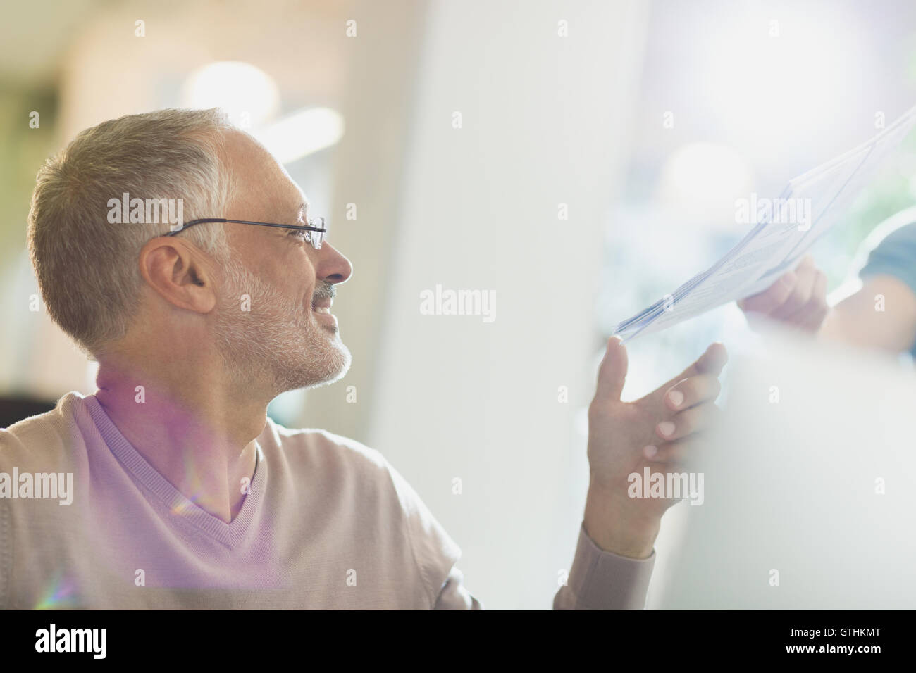 Businessman receiving paperwork in office Stock Photo - Alamy