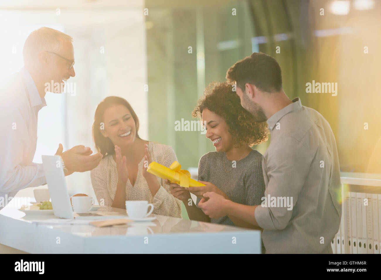 Colleagues giving businesswoman gift in office Stock Photo - Alamy