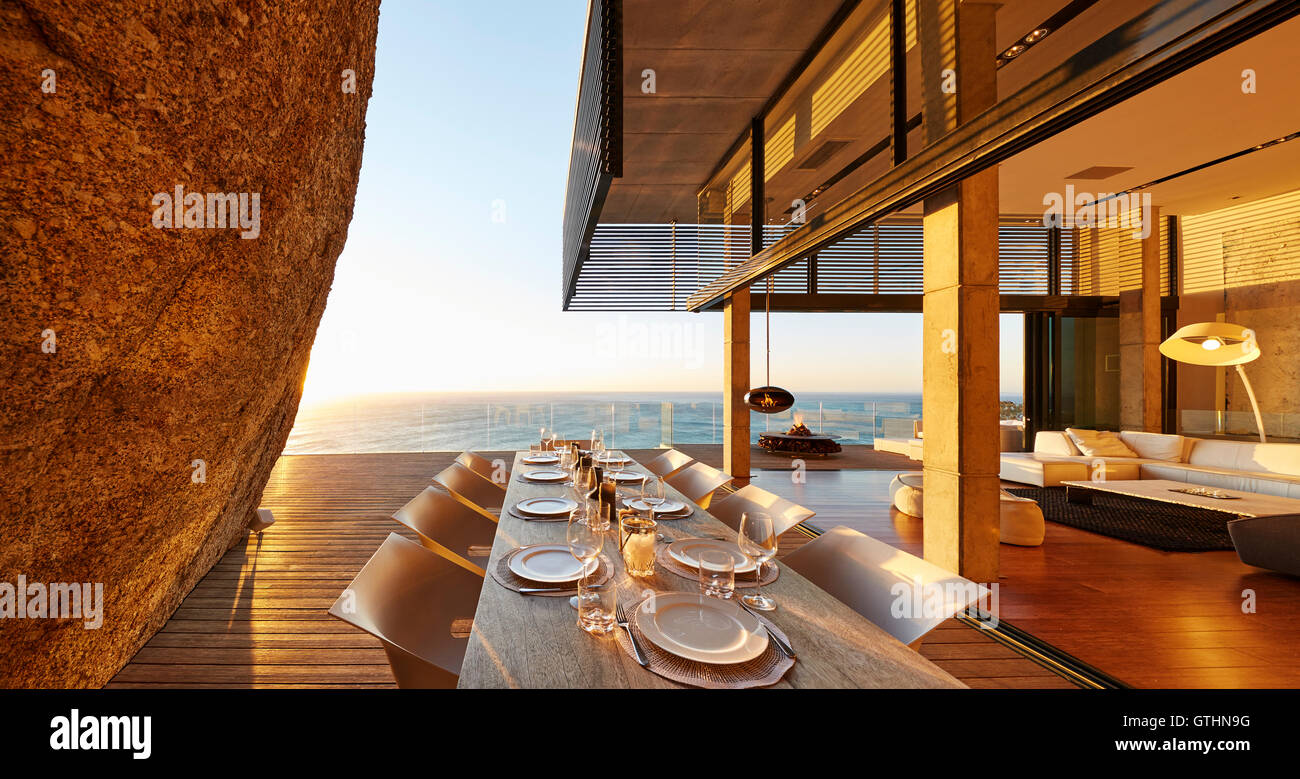 Modern luxury patio dining table with sunset ocean view Stock Photo - Alamy