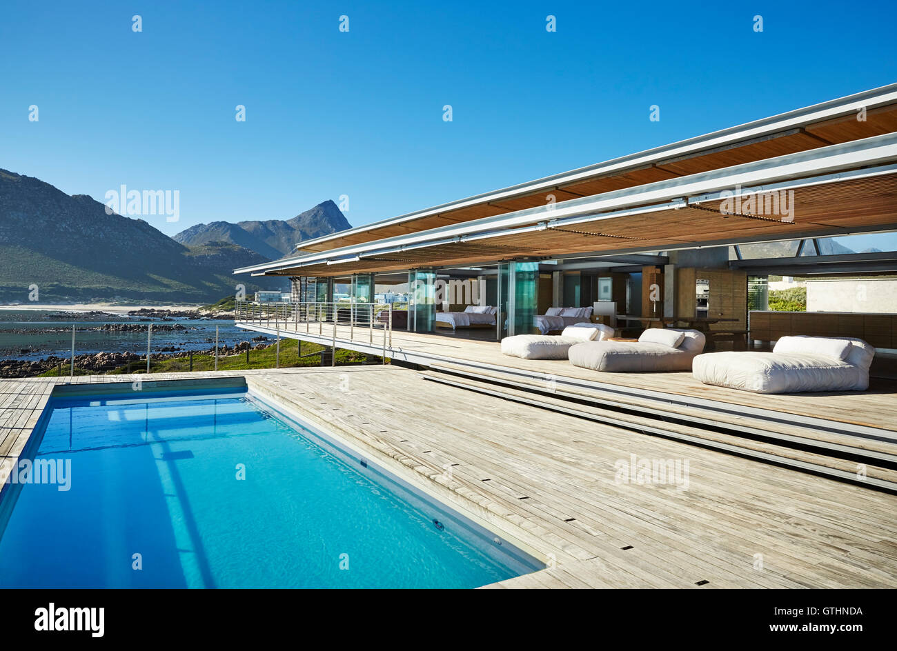 Modern luxury hotel swimming pool under sunny blue sky Stock Photo - Alamy