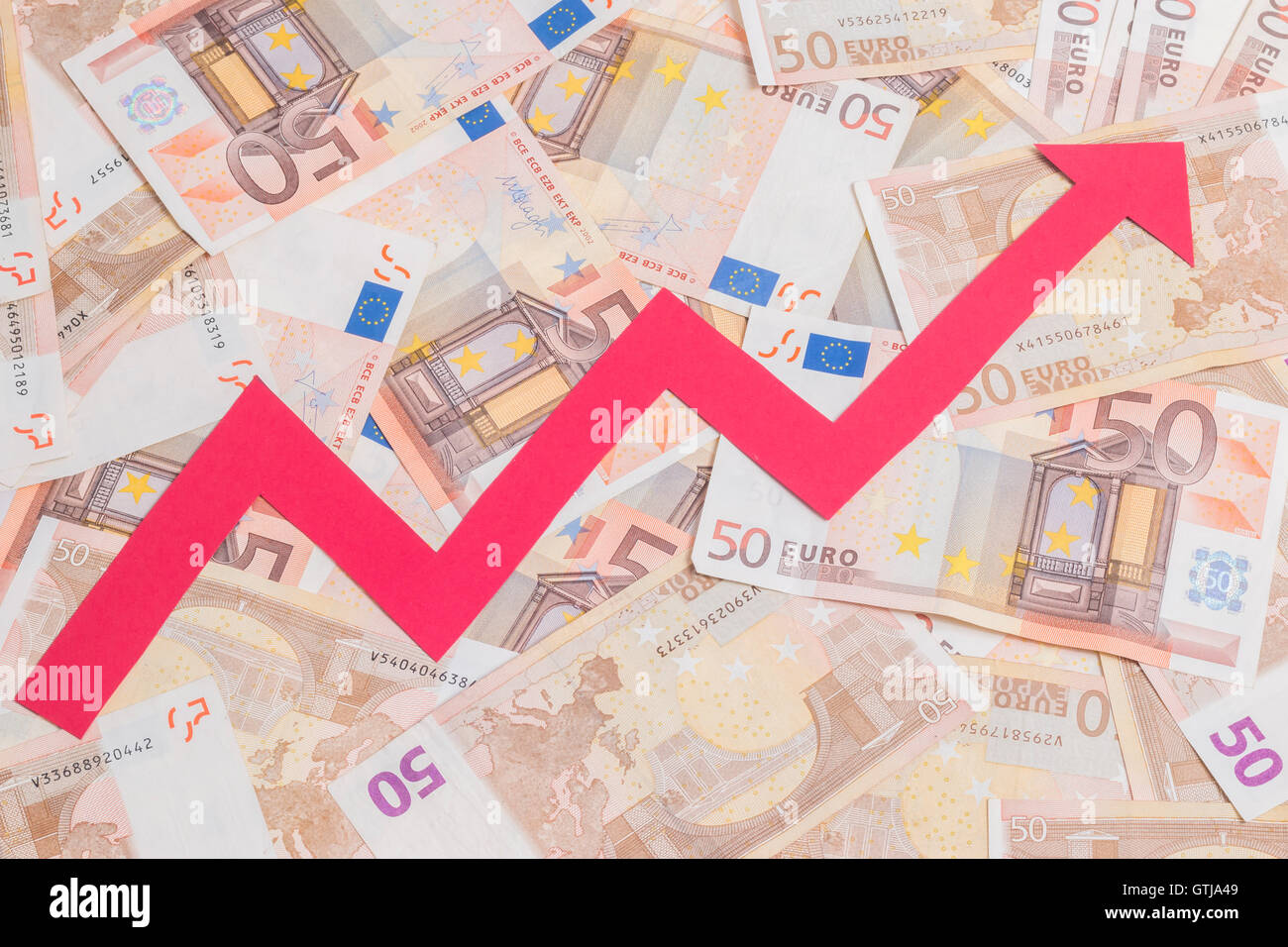 Concept of increase of euro value with red arrow growing over notes ...