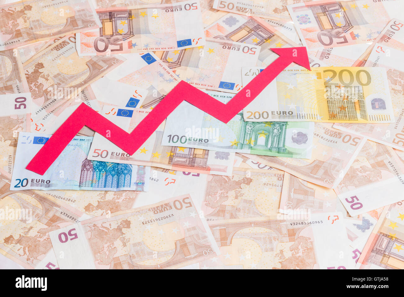 Concept of increase of euro value with red arrow growing over notes ...