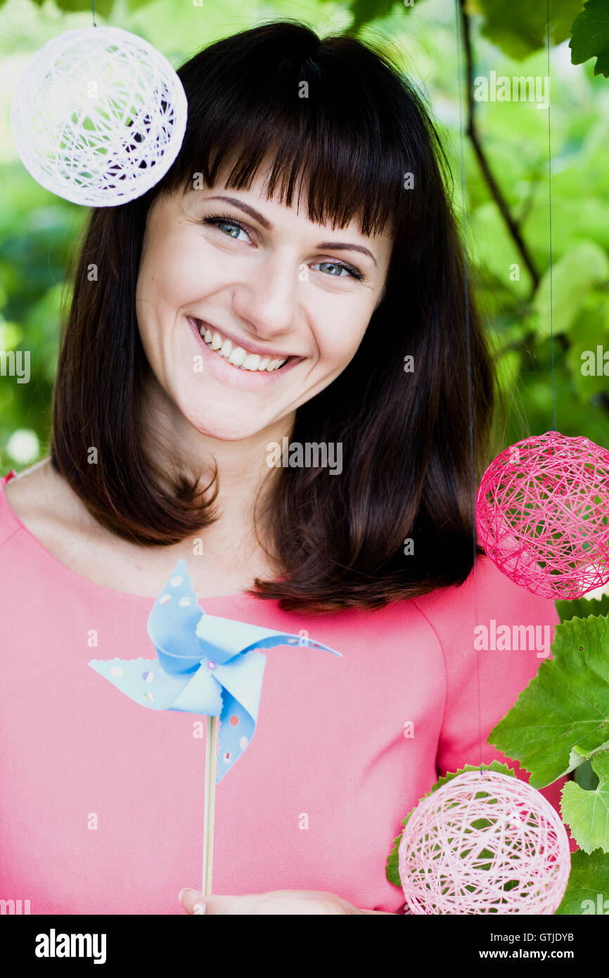 Beautiful girl laughing and holding a windmill Stock Photo - Alamy