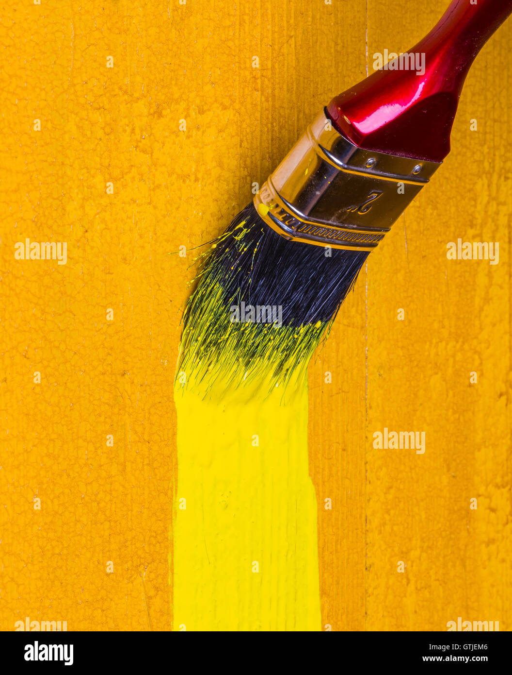 paintbrush with yellow paint dye wooden wall Stock Photo - Alamy