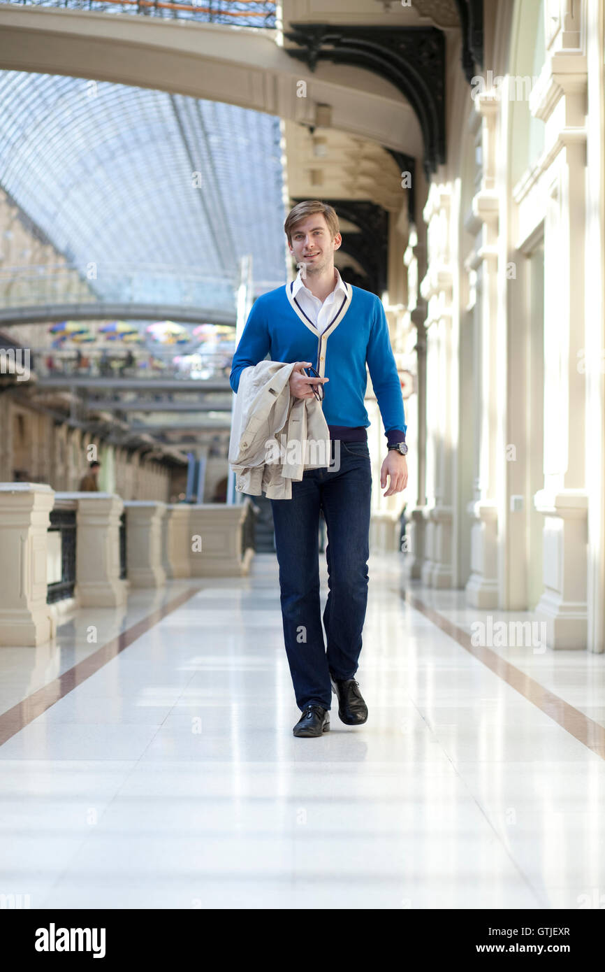 Young man walking in the store Stock Photo - Alamy