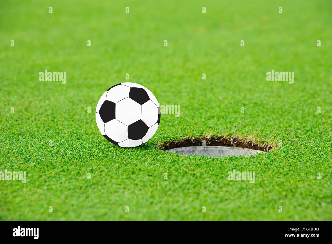 Football on Edge of Hole Stock Photo - Alamy