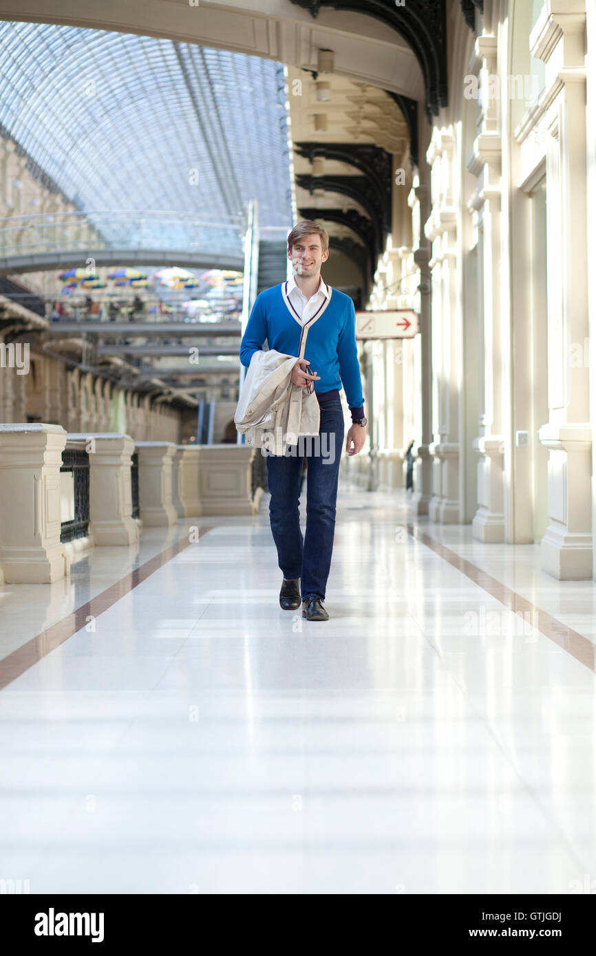 Young man walking in the store Stock Photo - Alamy