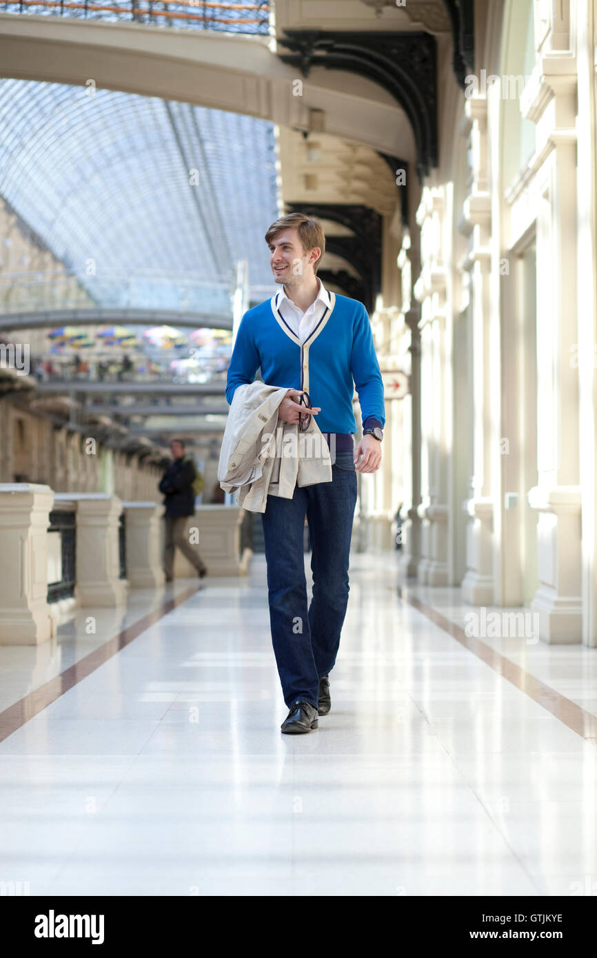 Young man walking in the store Stock Photo - Alamy