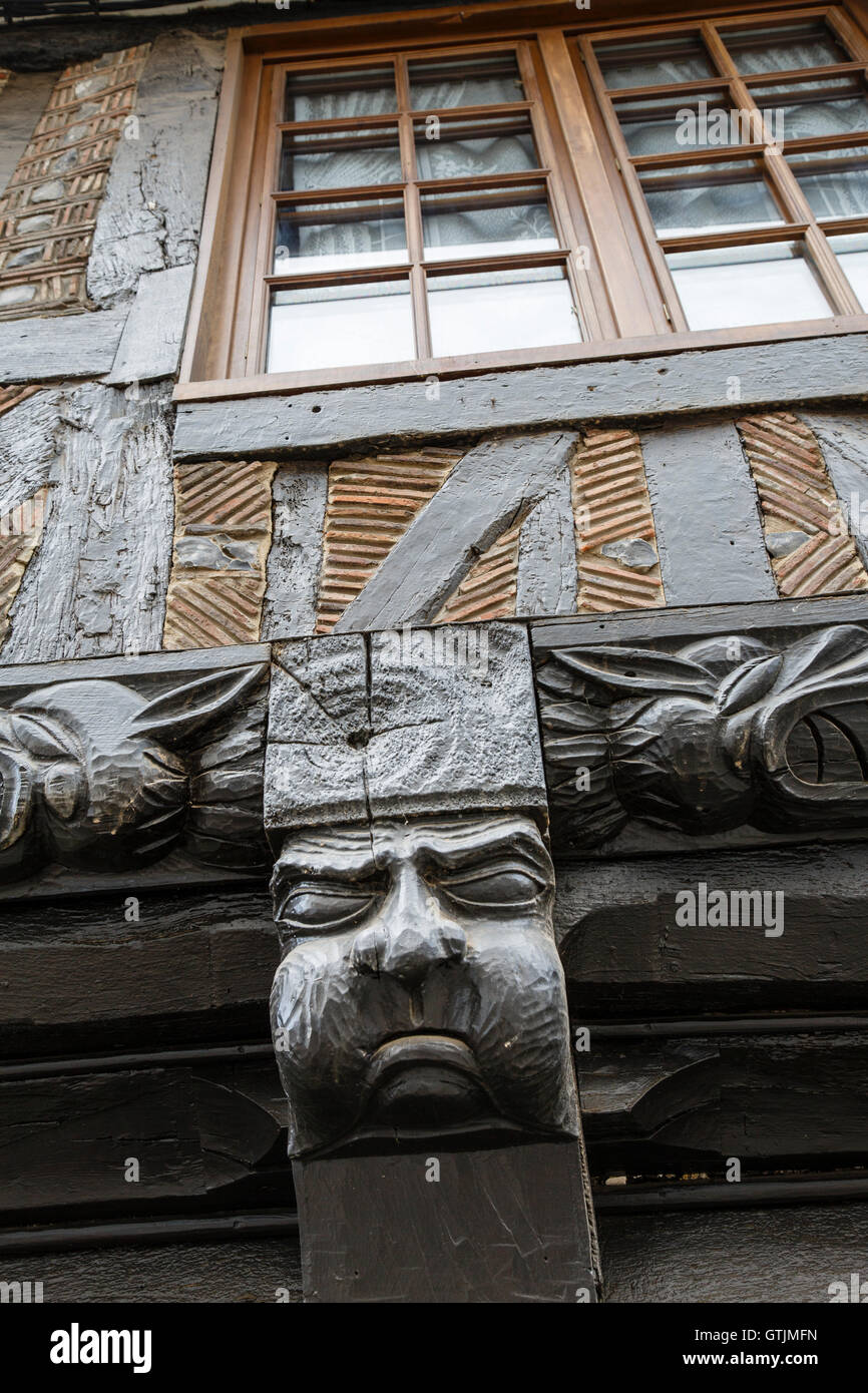 Carved wooden gargoyle on traditional Norman timber-framed building at ...