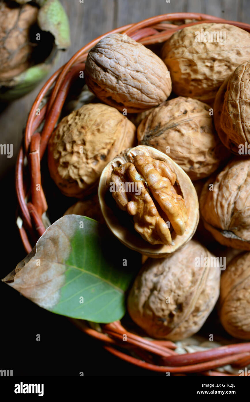 Walnut in basket and whole walnuts on rustic old wood Stock Photo - Alamy