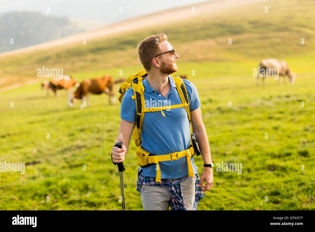 View of happy young man hiking in countryside Stock Photo - Alamy