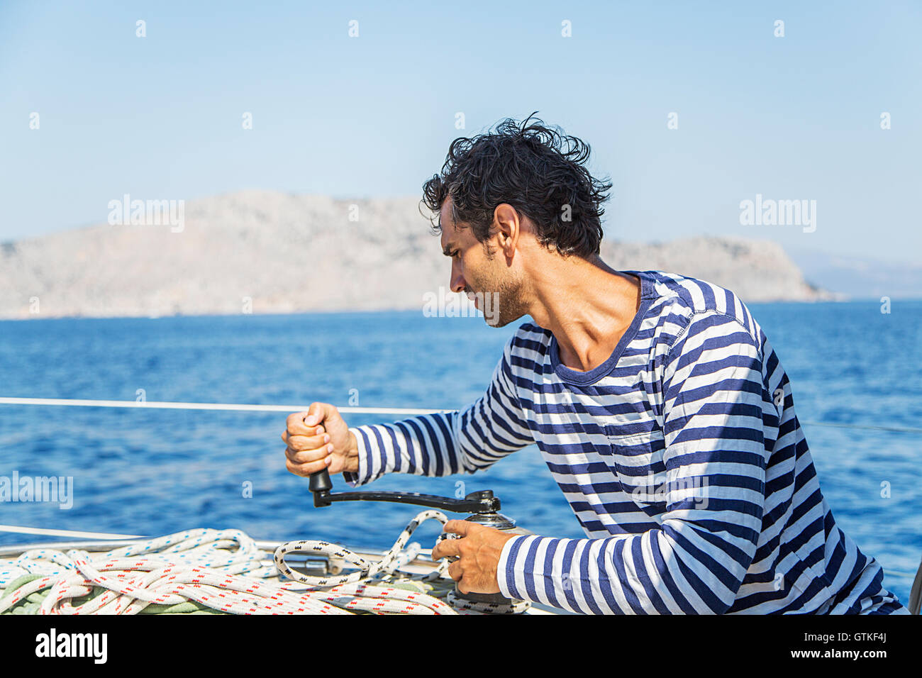 Young handsome sailor pulling rope on sailboat Stock Photo - Alamy