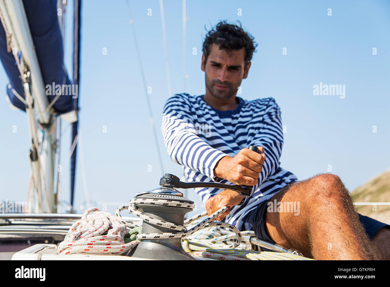 Young handsome sailor pulling rope on sailboat Stock Photo - Alamy