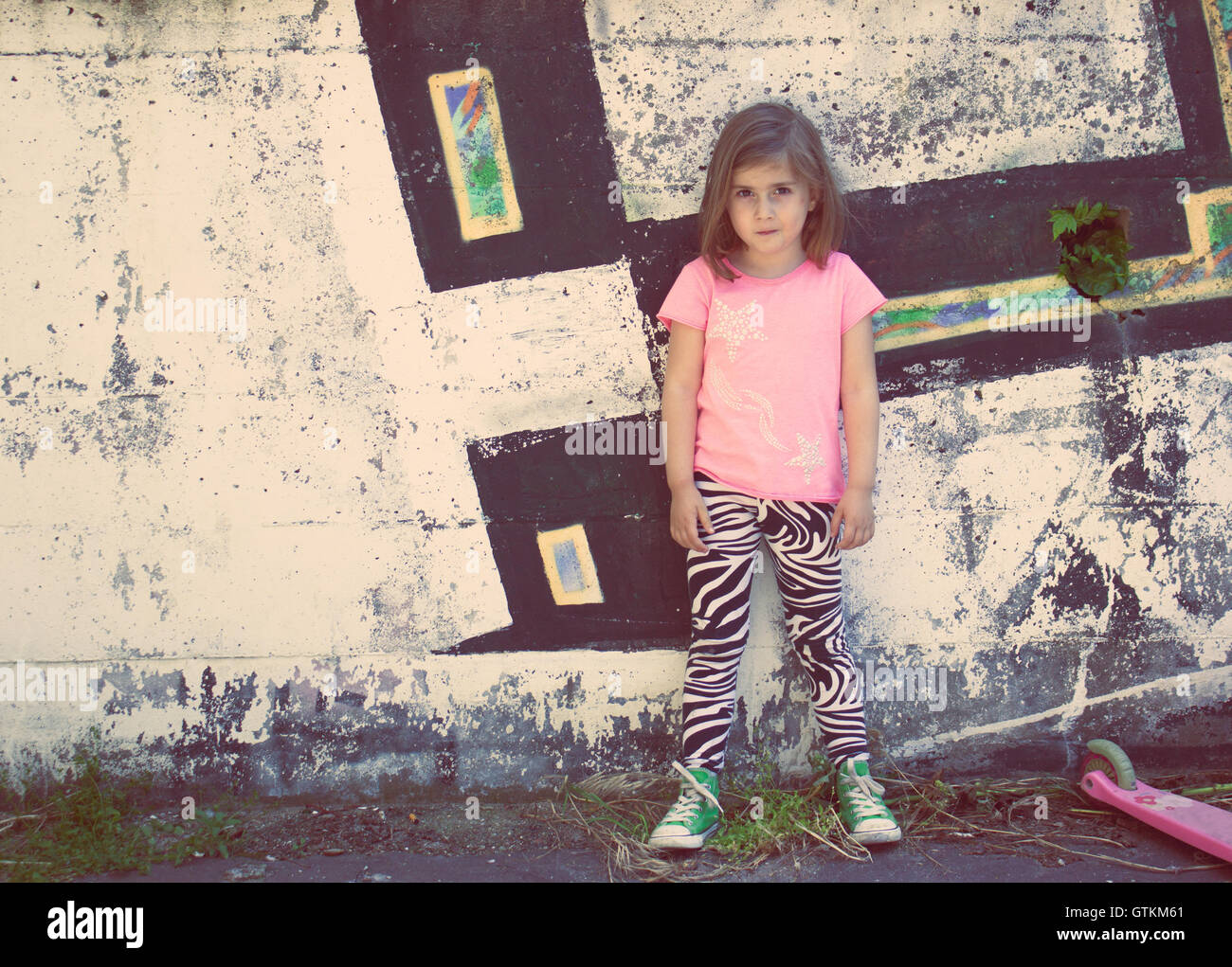 Little girl in front of graffiti wall Stock Photo - Alamy