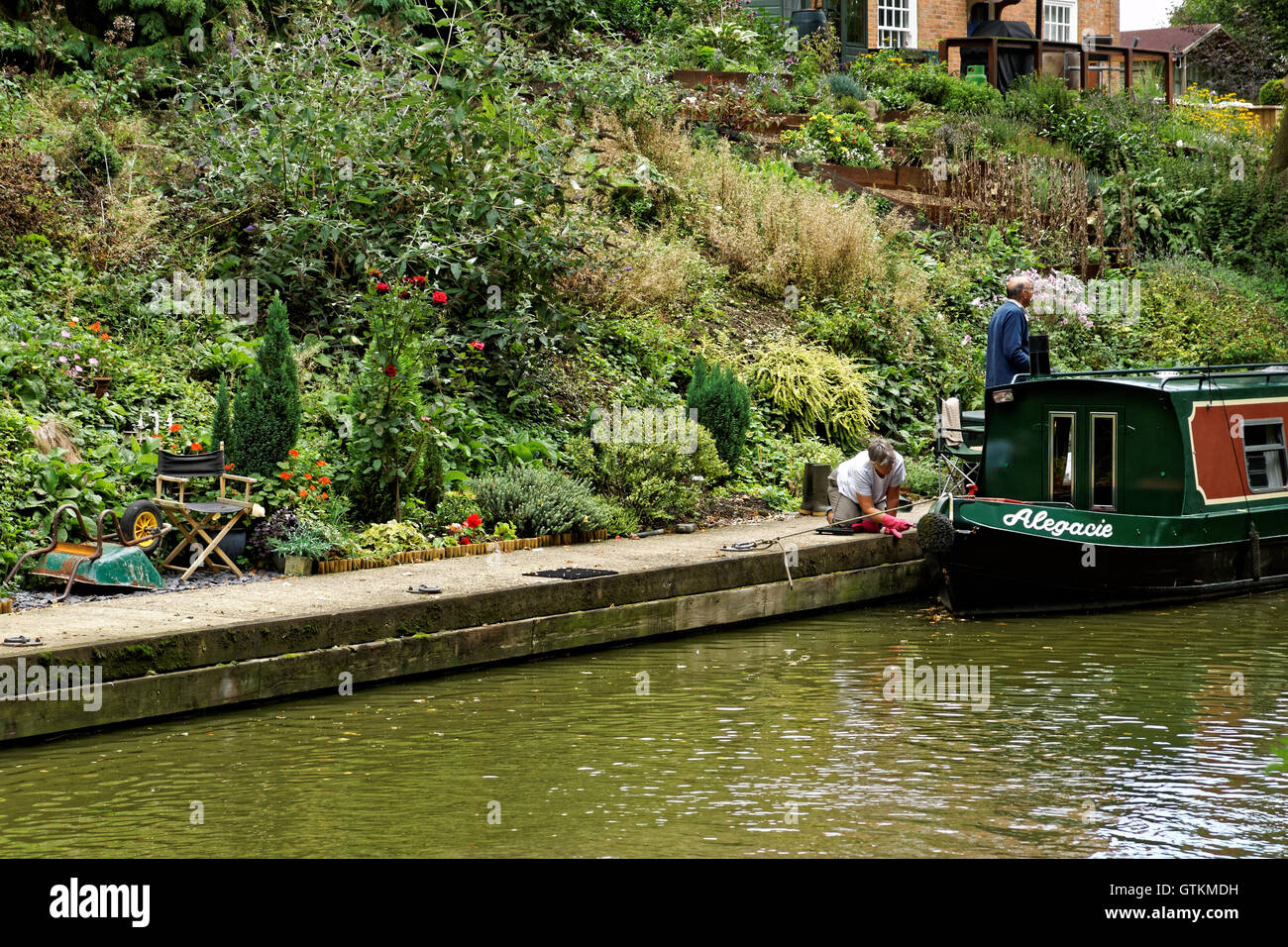 maintenance on narrowboat by canal side garden Stock Photo - Alamy