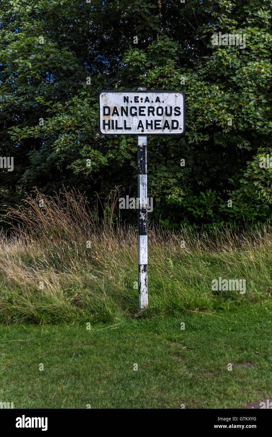 An old fashioned road sign post indicating a Dangerous hill ahead on a ...