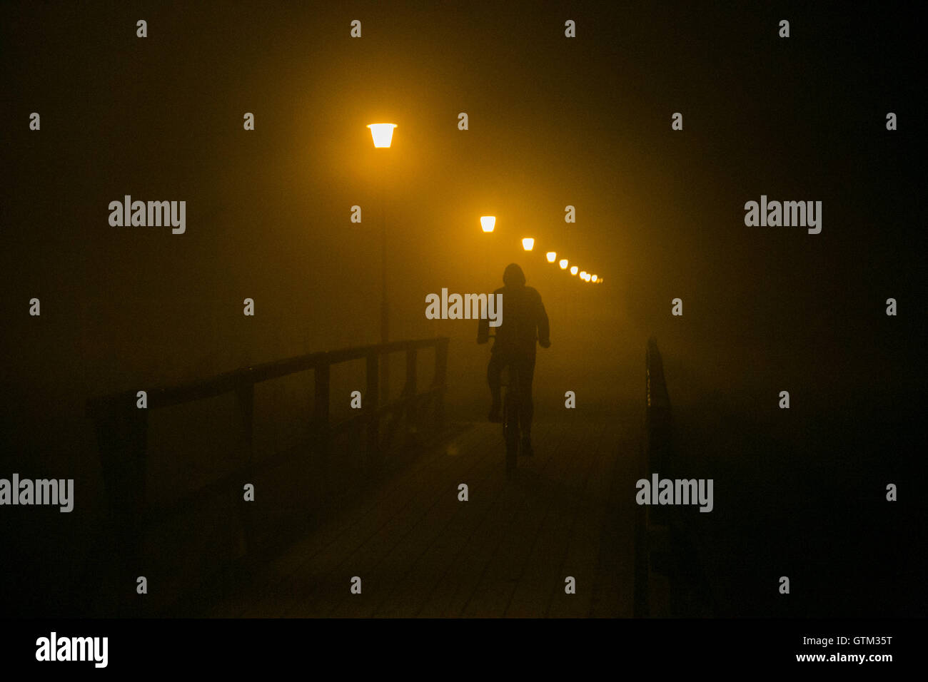 A bike rider rides in the night and fog in Landskrona,Sweden, 20th of August 2016 Stock Photo ...