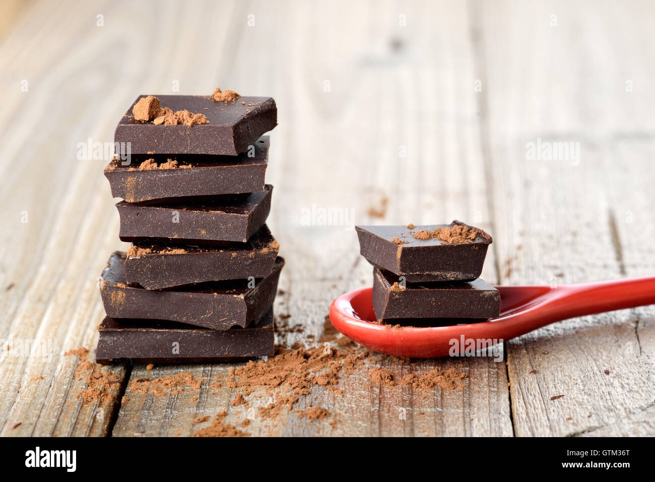 Chocolate pieces and cocoa on wooden table Stock Photo - Alamy