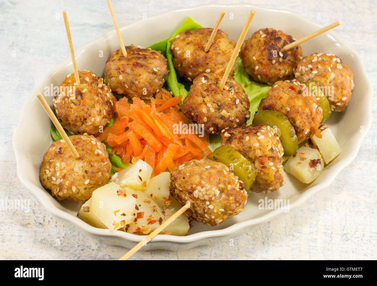 Meatballs on sticks in a plate with vegetables Stock Photo - Alamy