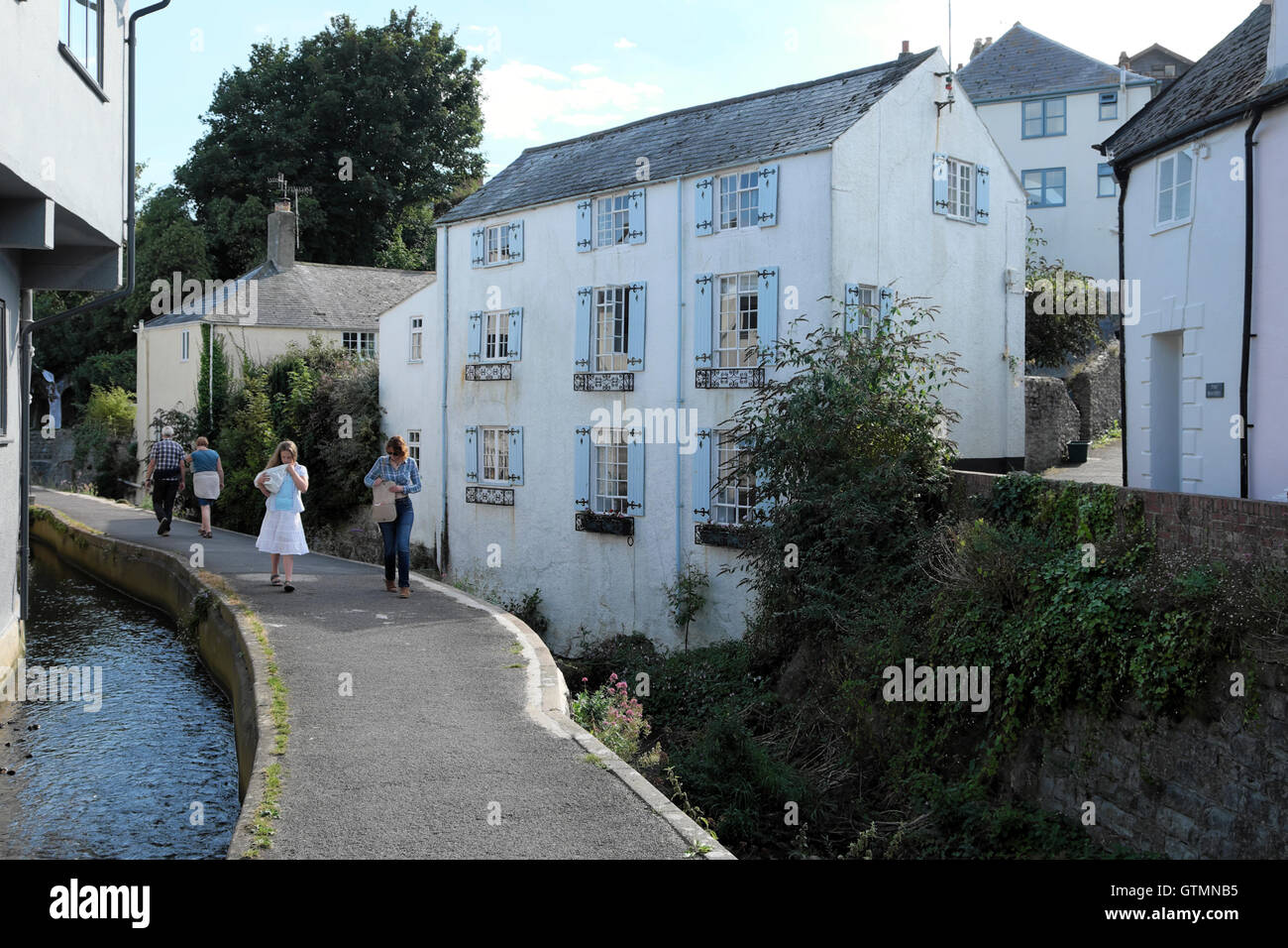 Young women walking along the River Lym Mill Race which flows through ...