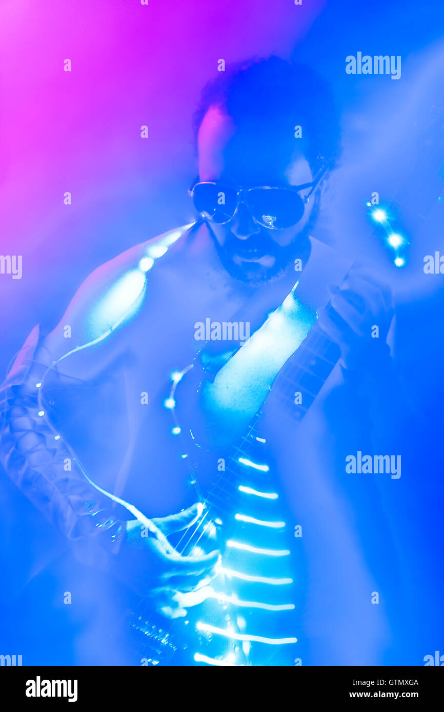 Rock star playing solo on guitar, neon lights Stock Photo - Alamy