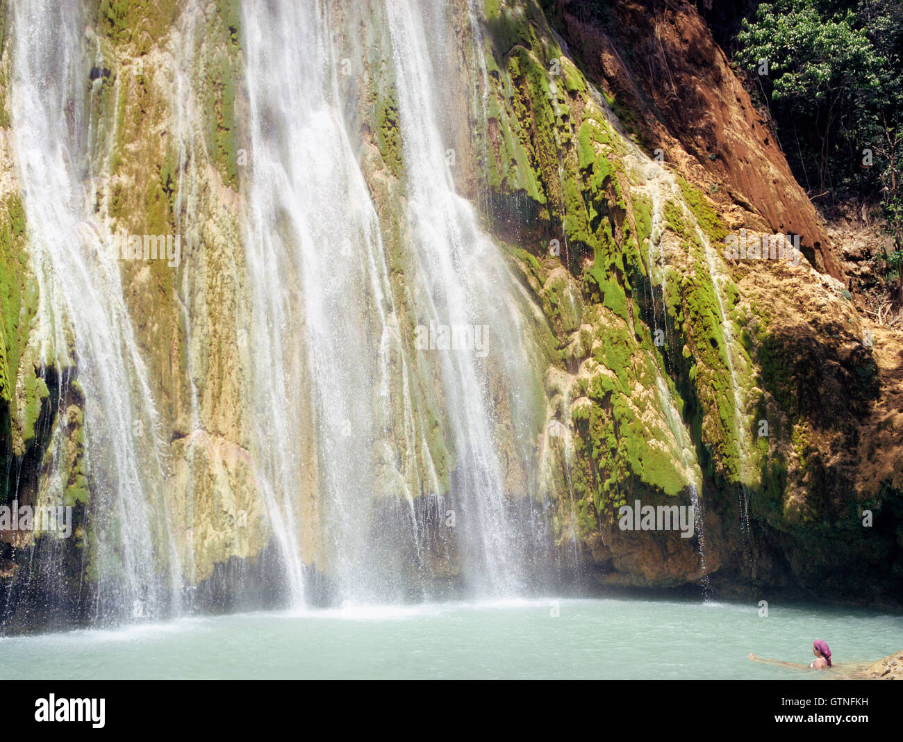 A young woman relaxes at El Limon waterfall.(Salto de Limon).Of the ...