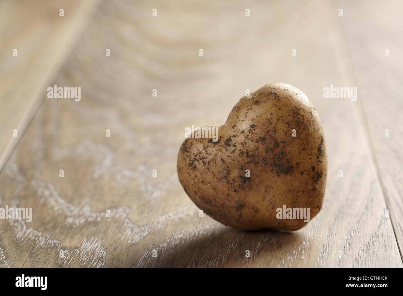 heart shaped potato on oak table Stock Photo - Alamy