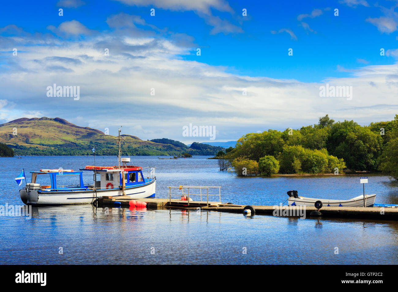 Small ferry at a pier on Loch Lomond, Luss, Scotland, UK Stock Photo ...