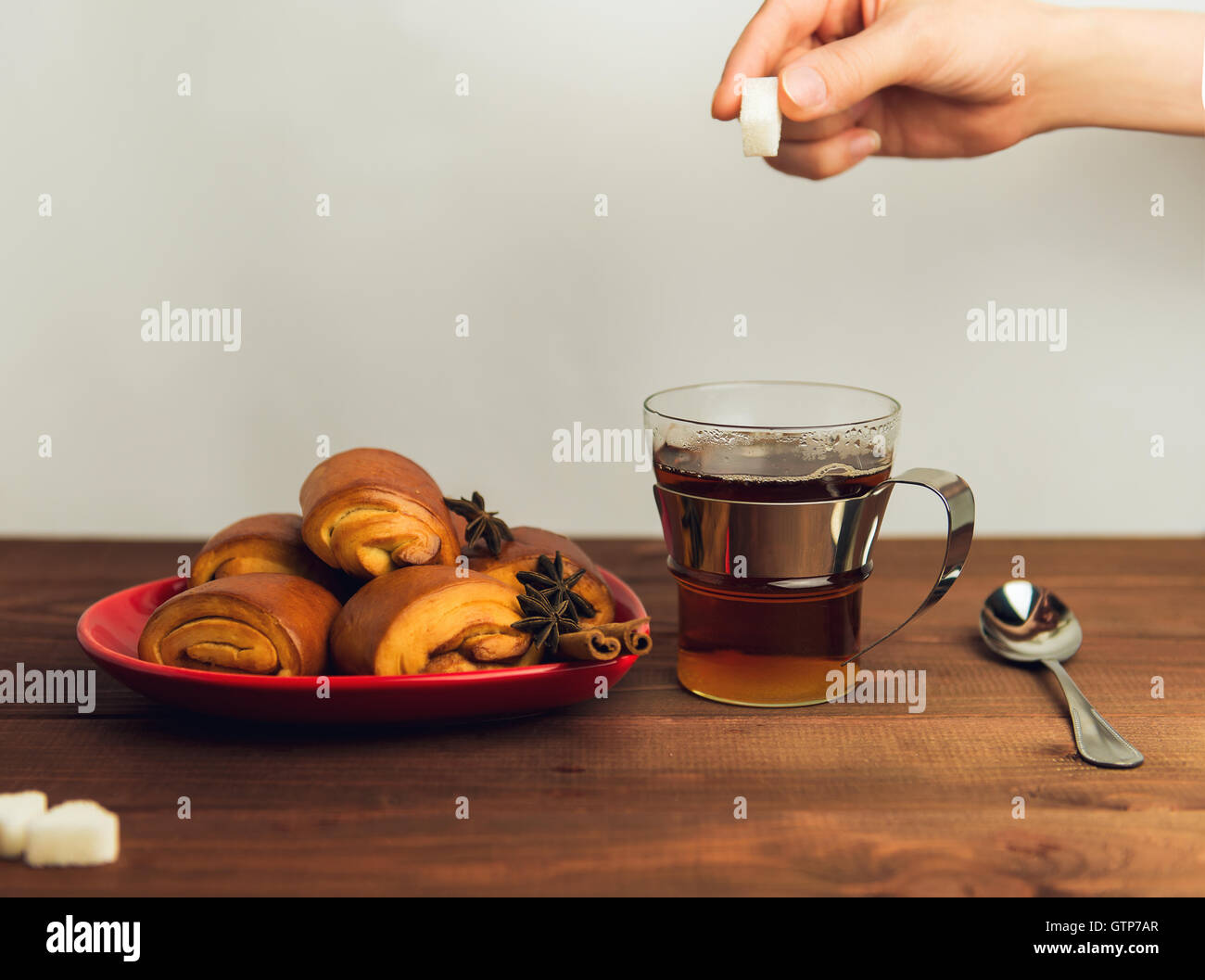 Female hand throwing a lump of sugar in a glass cup of tea, which ...