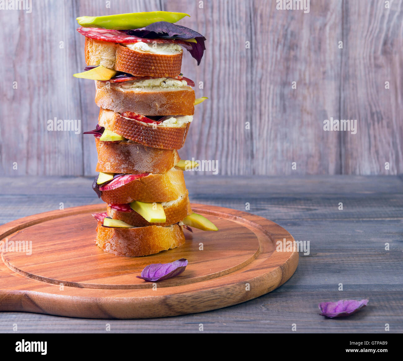 Small tapas sandwiches with bread, cheese, sausage meat, avocado and ...