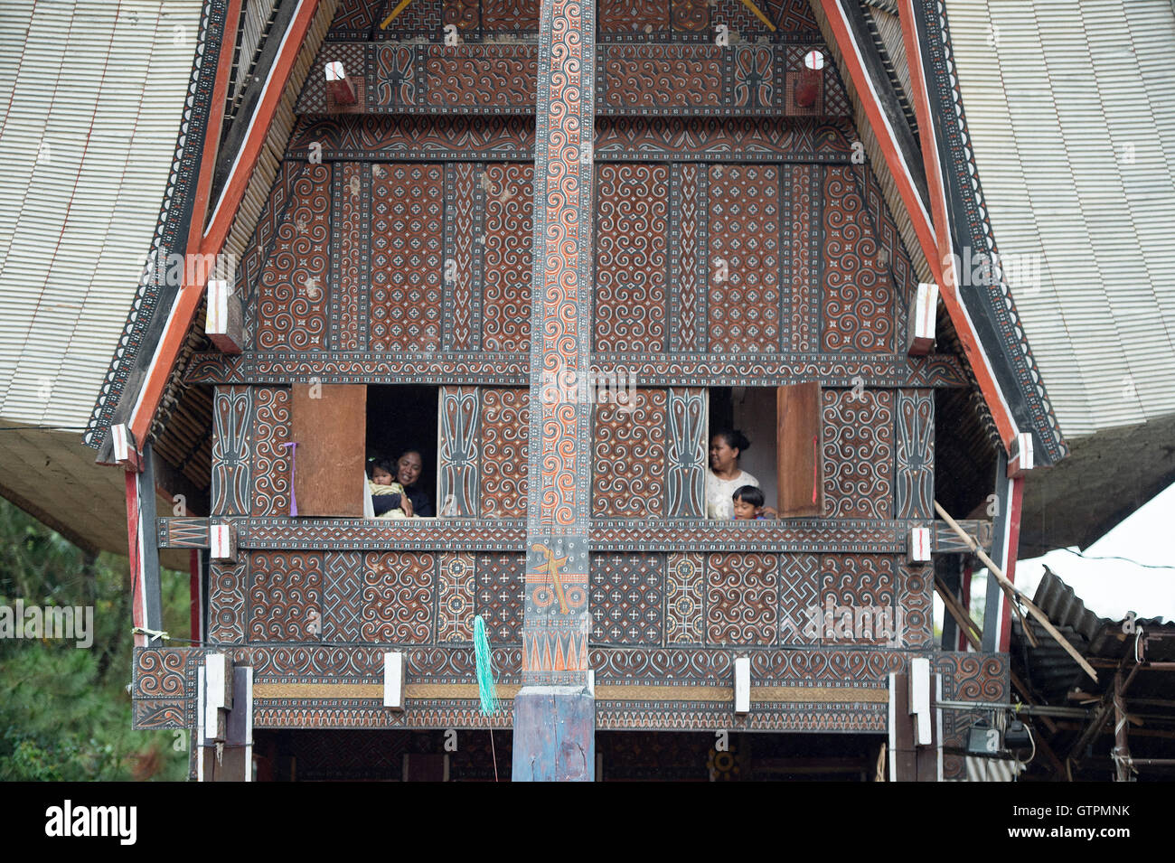 Toraja family pose for camera at the window of Toraja traditional house ...