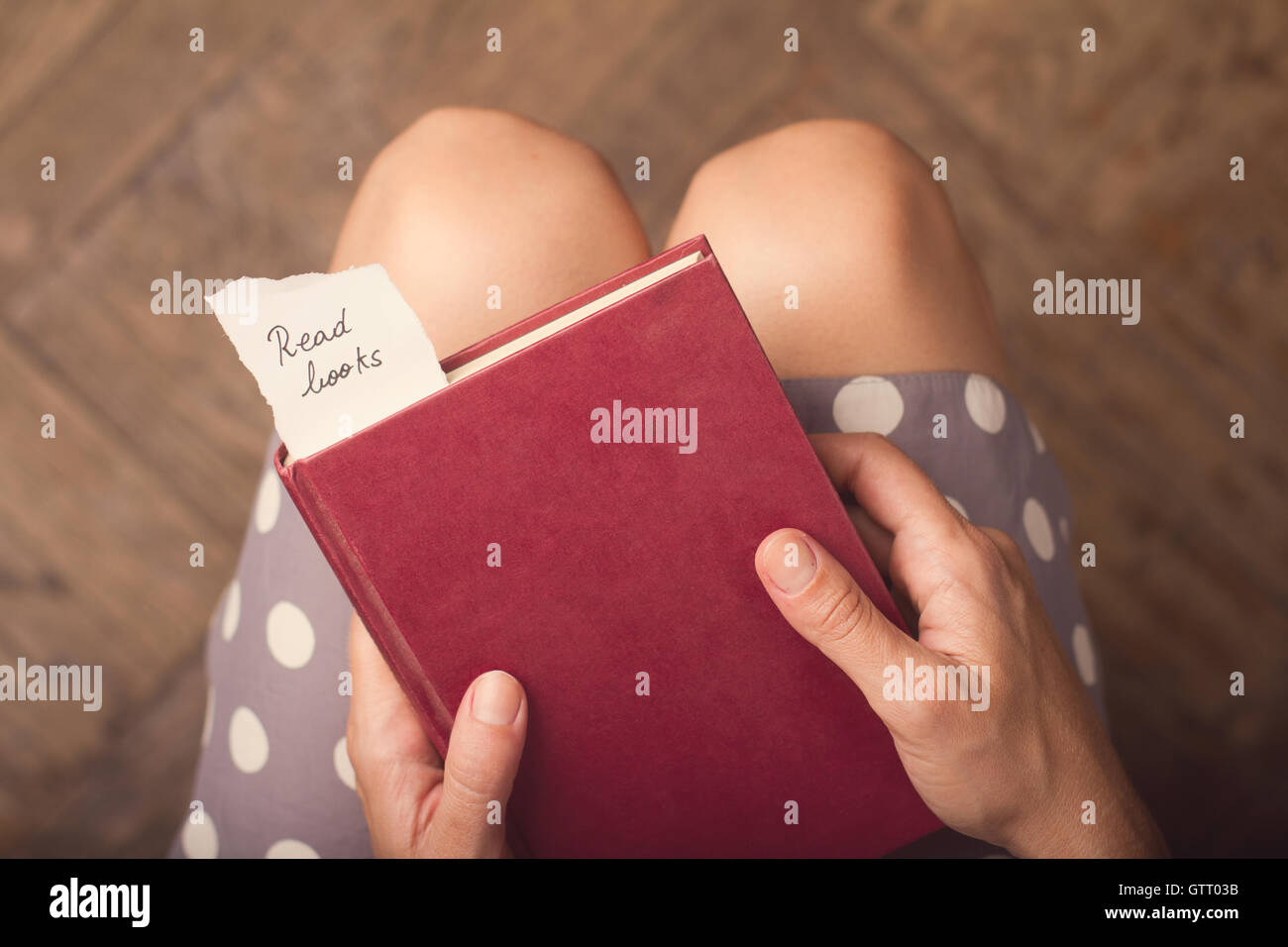 Hand holding a book with note of paper with the message read books on ...