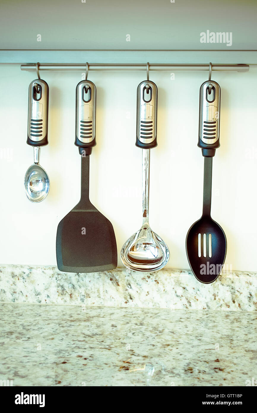 set of kitchen utensils hanging on the wall Stock Photo - Alamy