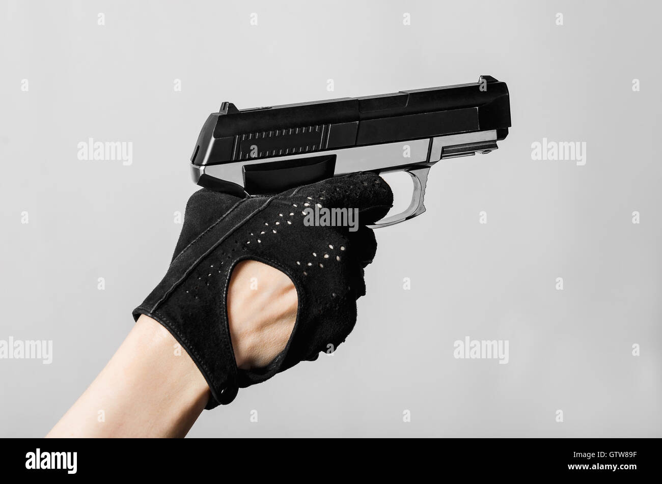 Female hand with a pistol in a black glove aim and pulled the trigger ...