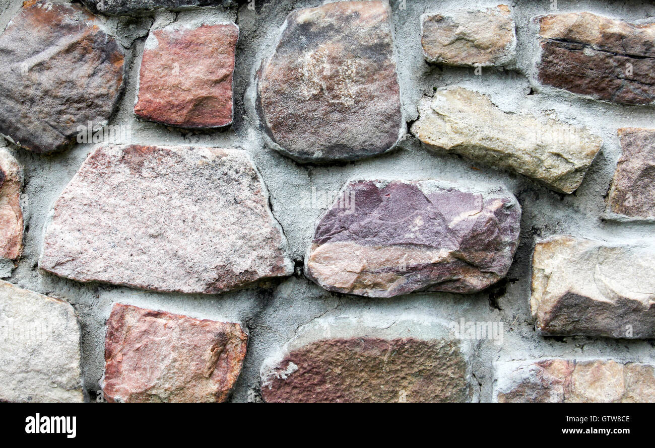 Several rocks make a field stone wall background Stock Photo - Alamy