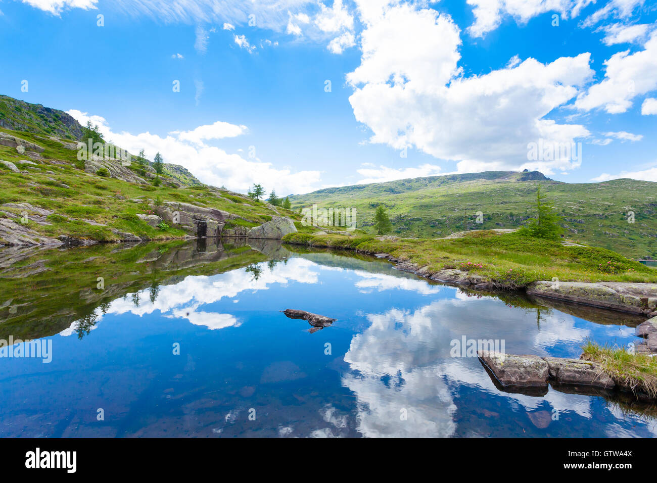 Italian mountain panorama, clouds reflected on alpine lake. Trekking ...