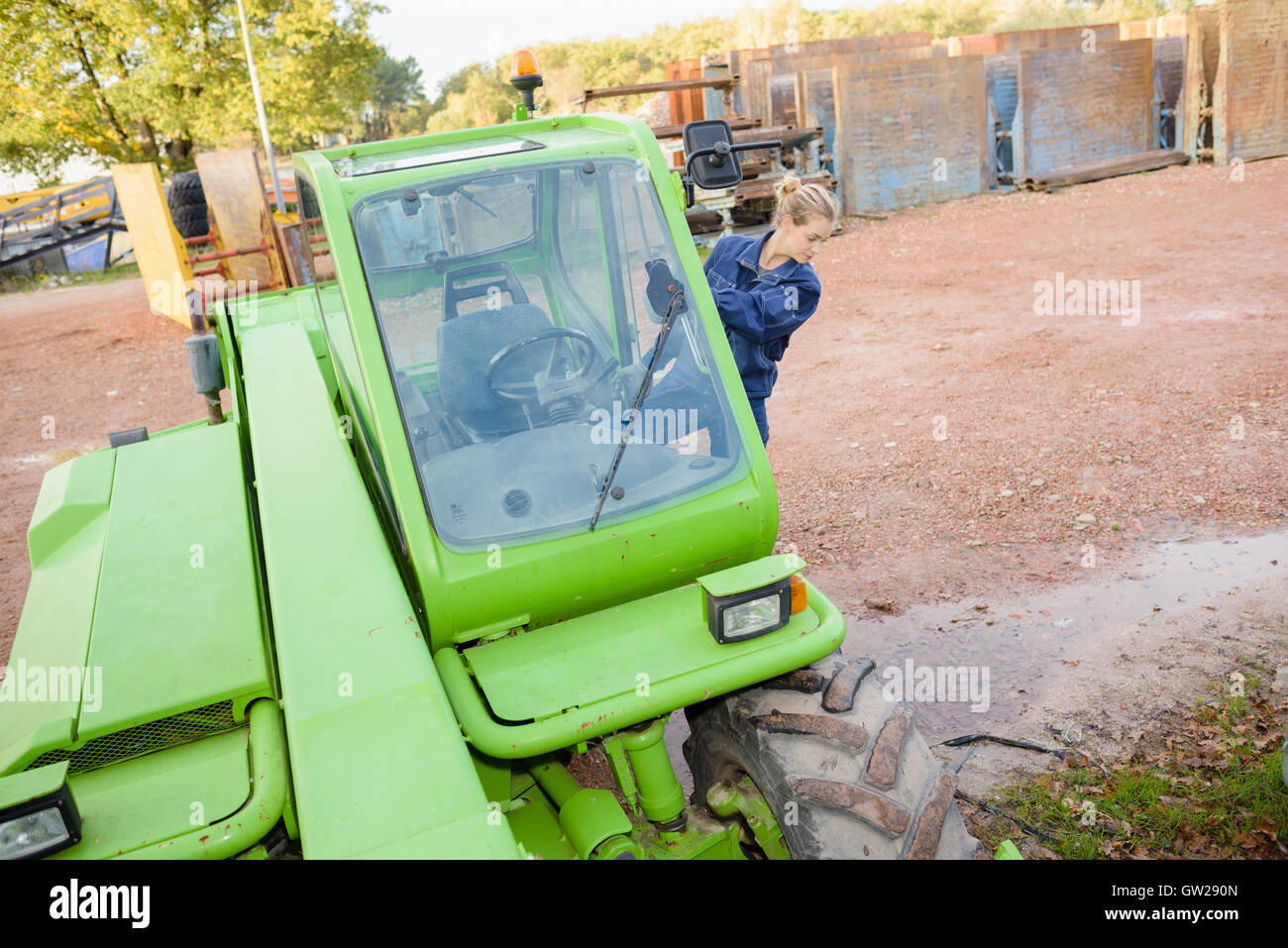 Woman getting in telehandler Stock Photo - Alamy