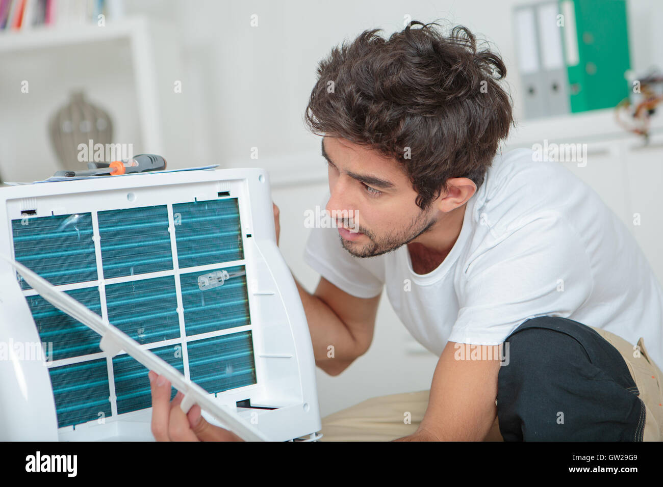 Man fixing air conditioning unit Stock Photo - Alamy