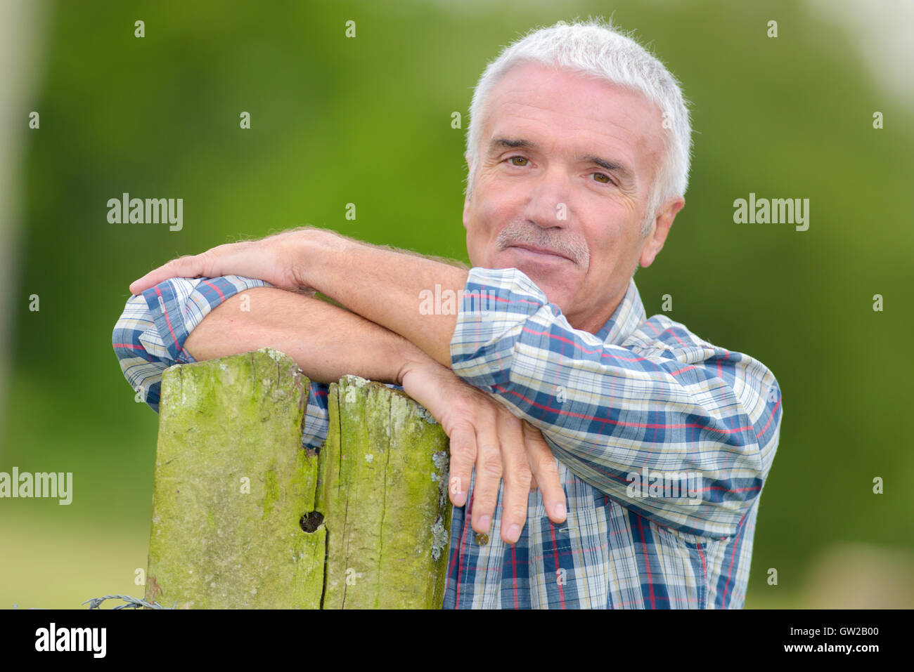 mature man leaning on post Stock Photo - Alamy