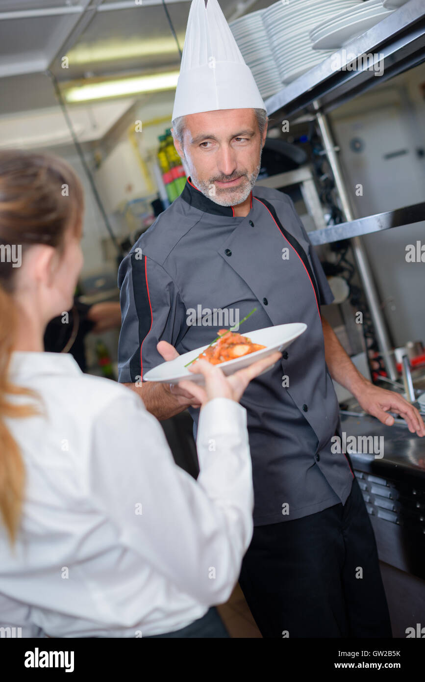 cook giving a prepared meal Stock Photo - Alamy