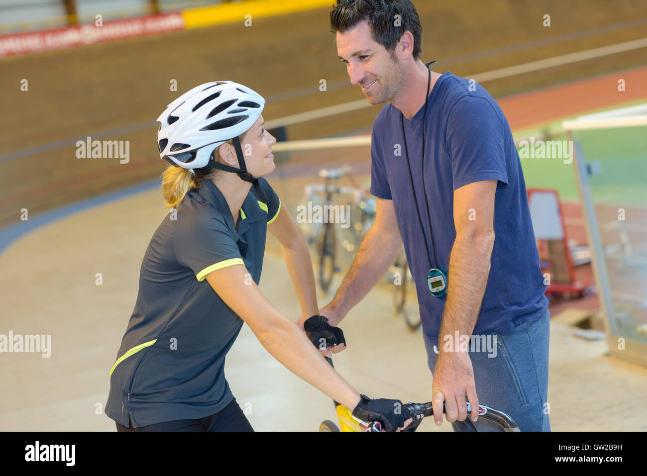Trainer and cyclist talking over bicycle Stock Photo - Alamy