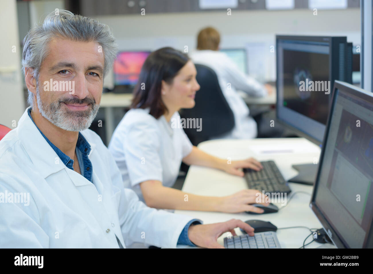 Portrait of man in white coat using computer Stock Photo - Alamy